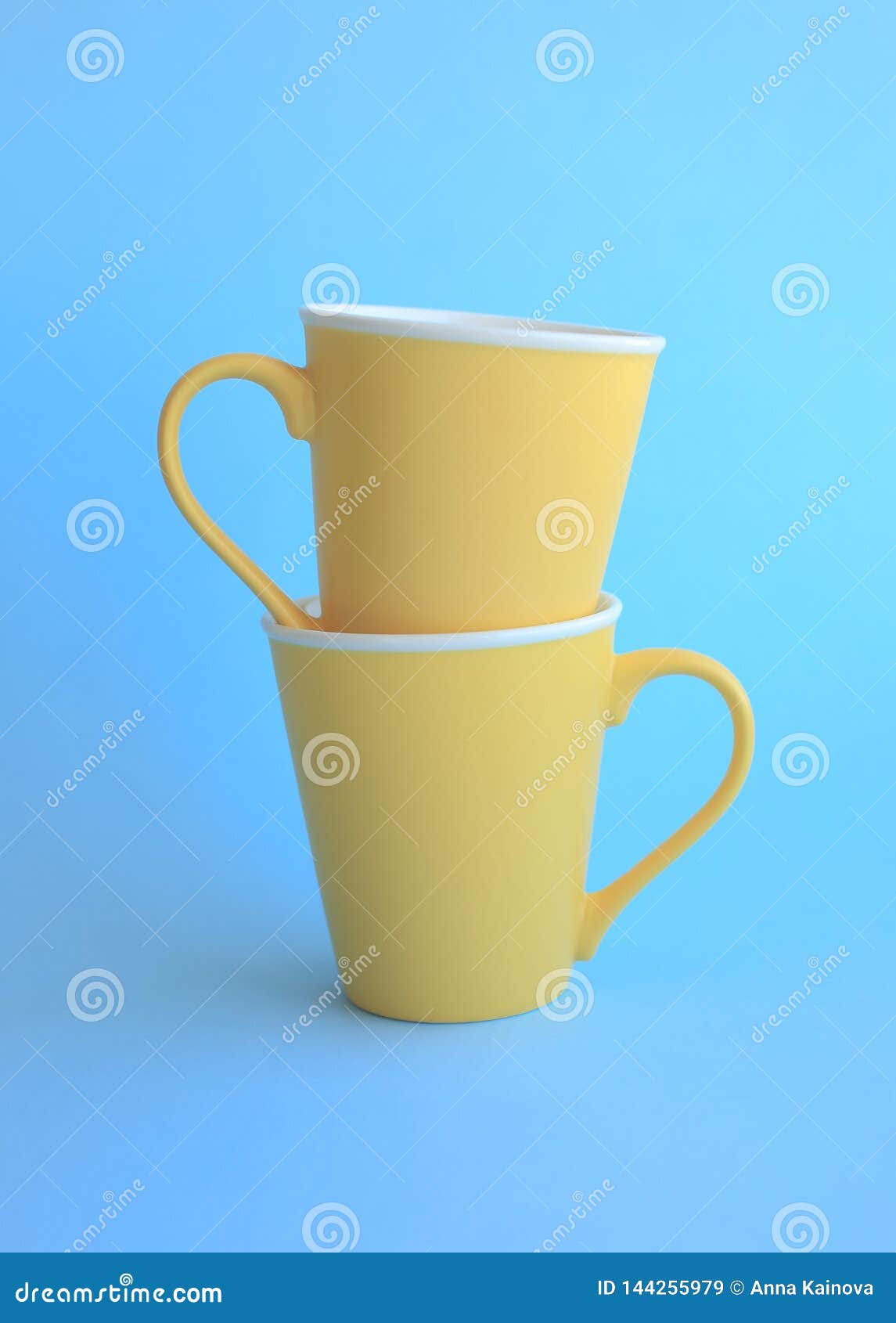 Two yellow cups on blue stock image. Image of colour - 144255979