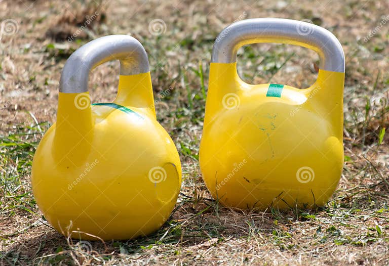Two Yellow Weights on the Ground in the Park Stock Photo - Image of ...
