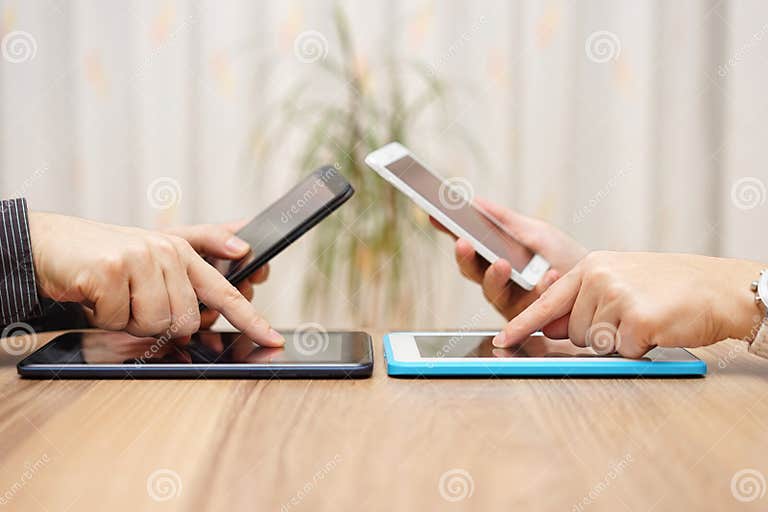 Two Young Adults are Using Multiple Tablets and Phones in Their Stock ...