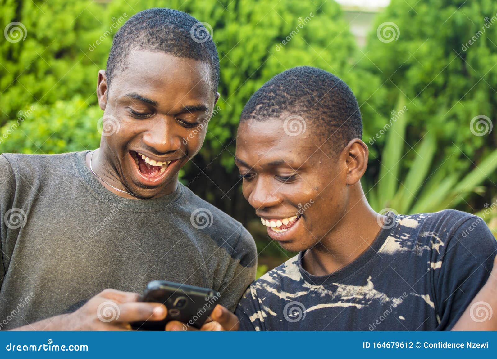 Two Young African Men Viewing Interesting Content on a Phone Together ...