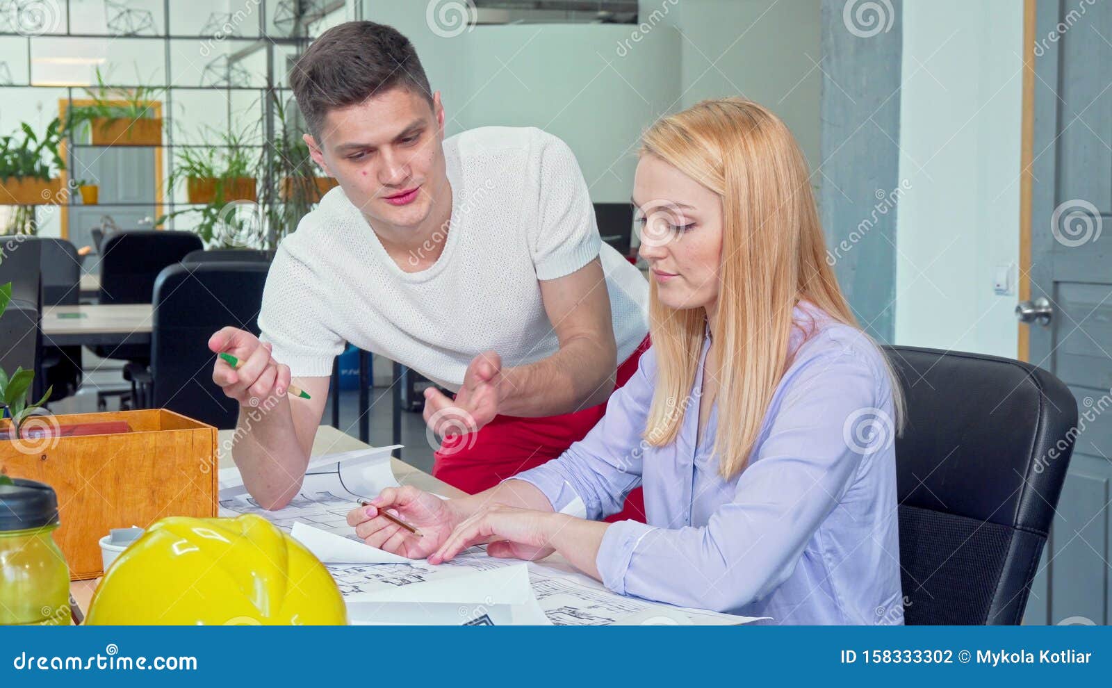 Two Young Architects Discussing Building Plan at the Office Stock Photo ...