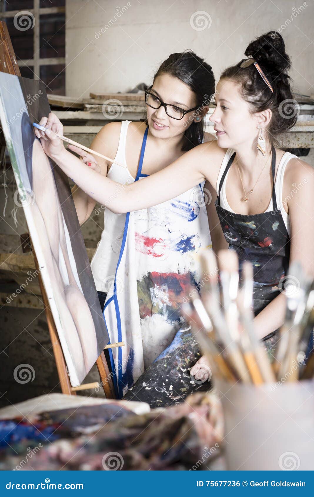 Two Young Artists Working Together on a Painting Stock Photo - Image of ...