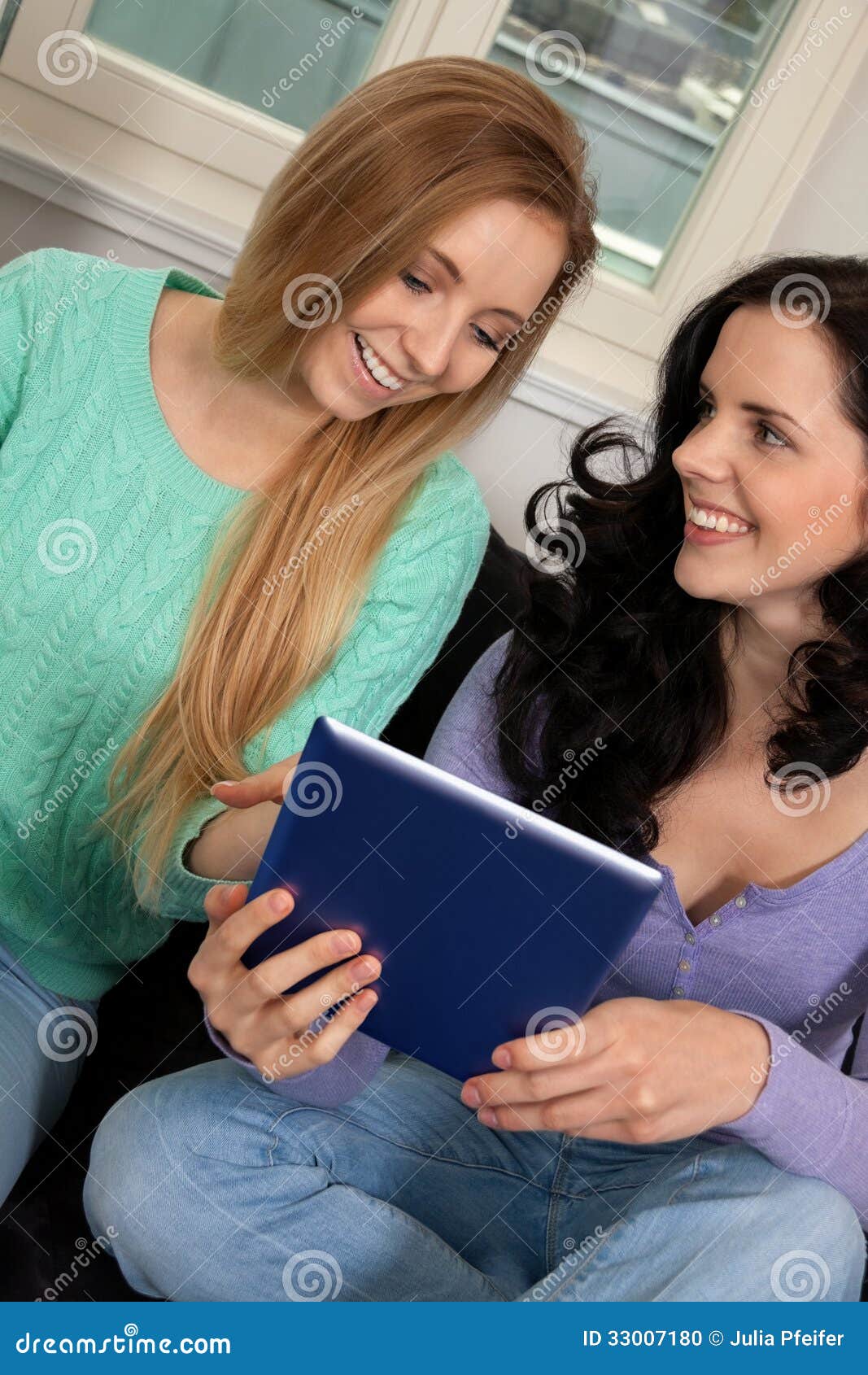 Two Young Attractive Girl with Tablett Pc on Couch Stock Photo - Image ...