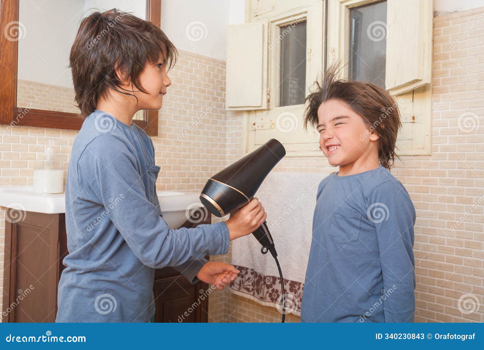 Two Young Boys are Drying Their Hair with a Blow Dryer Stock Image ...