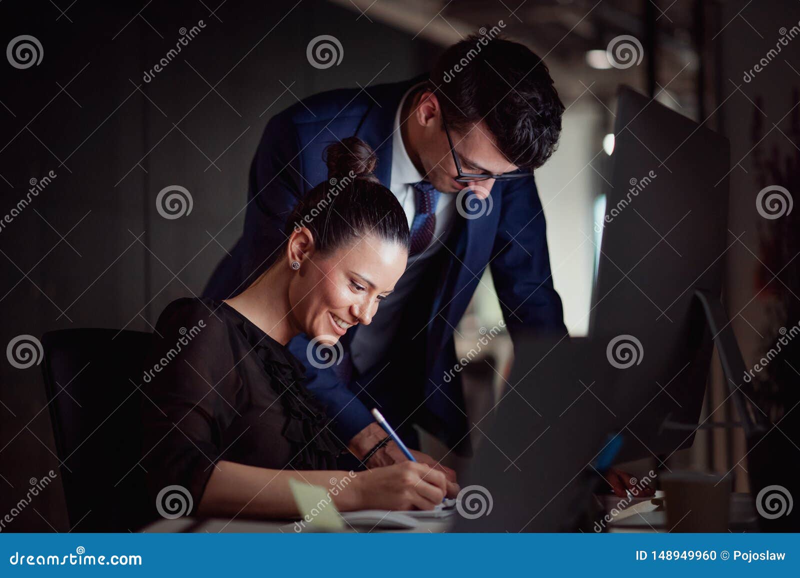 Young Business People in an Office at Night, Using Computer. Stock ...