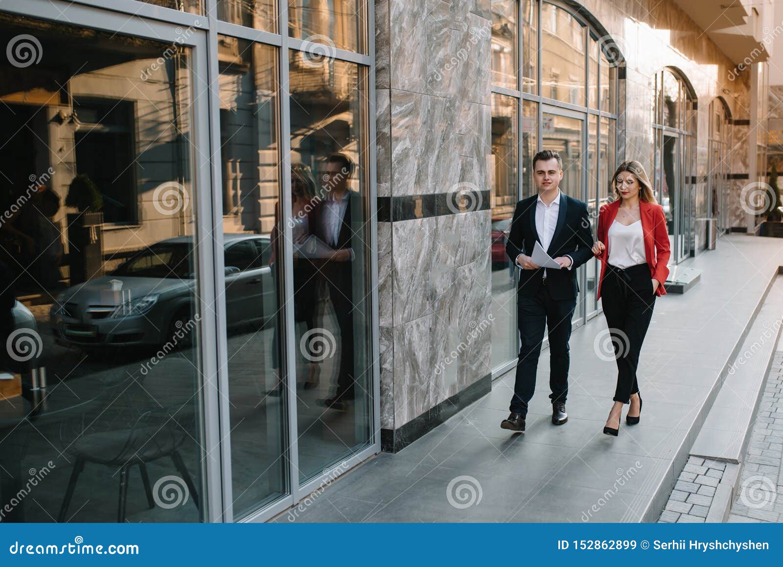 A Two Young Business-people are Walking Along Office Building Stock ...