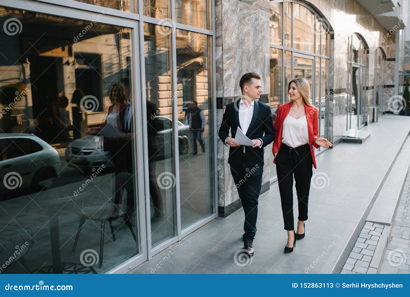 A Two Young Business-people are Walking Along Office Building Stock ...