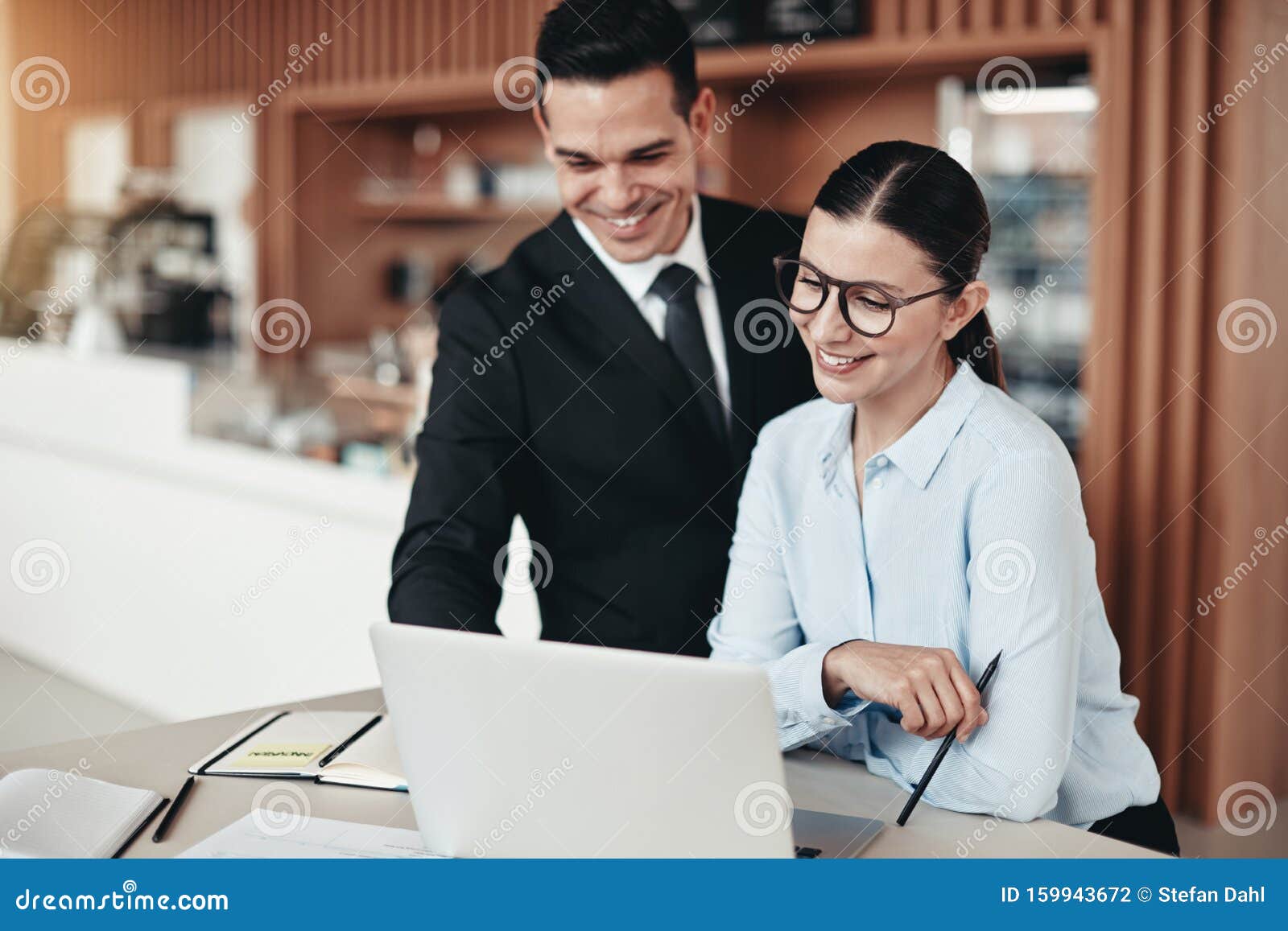 Two Young Businesspeople Working on a Laptop in an Office Stock Photo ...