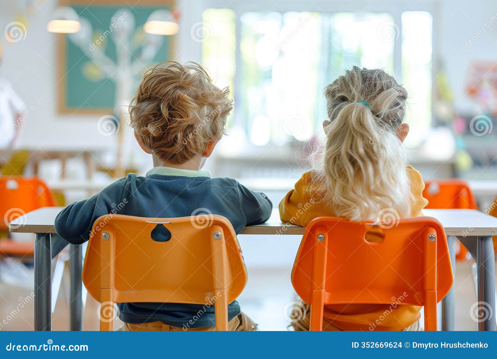 Two Young Children Sit Side by Side in a Classroom, Ready for Learning ...
