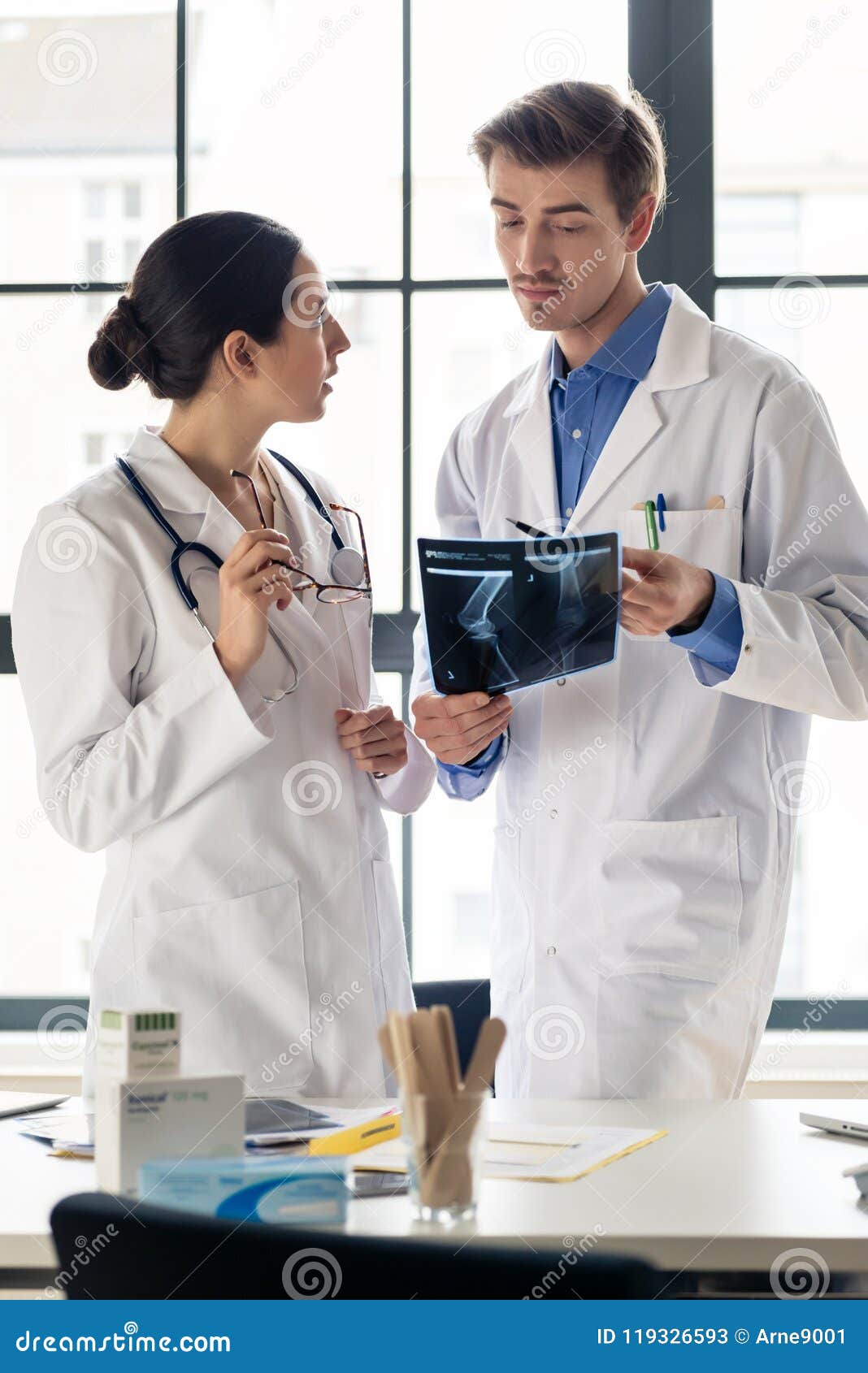 Two Young Dedicated Doctors Analyzing Together The Radiograph Of A ...