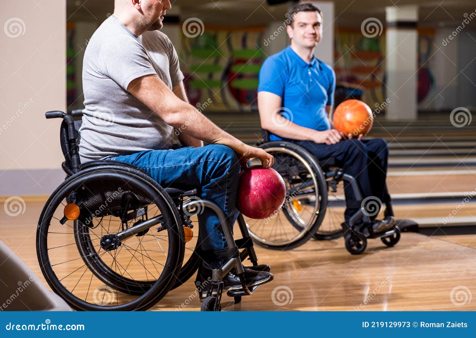 Two Young Disabled Men in Wheelchairs Playing Bowling in the Club Stock ...