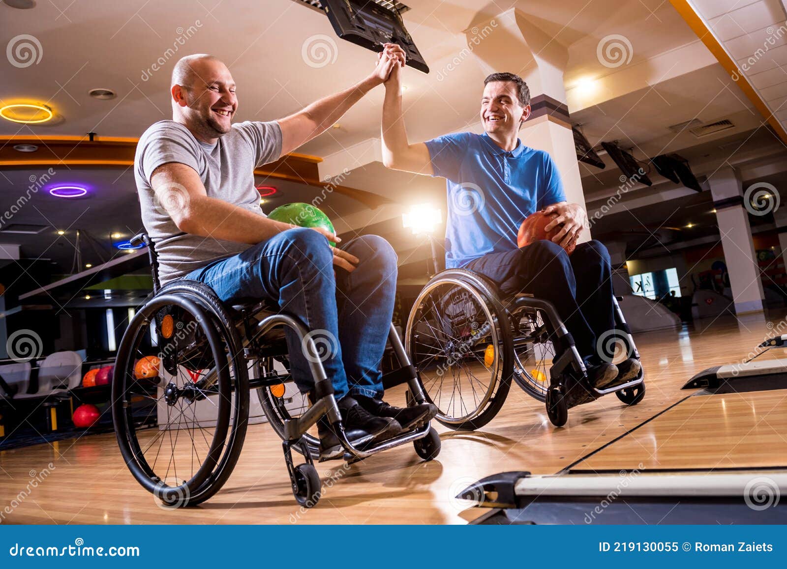 Two Young Disabled Men in Wheelchairs Playing Bowling in the Club Stock ...