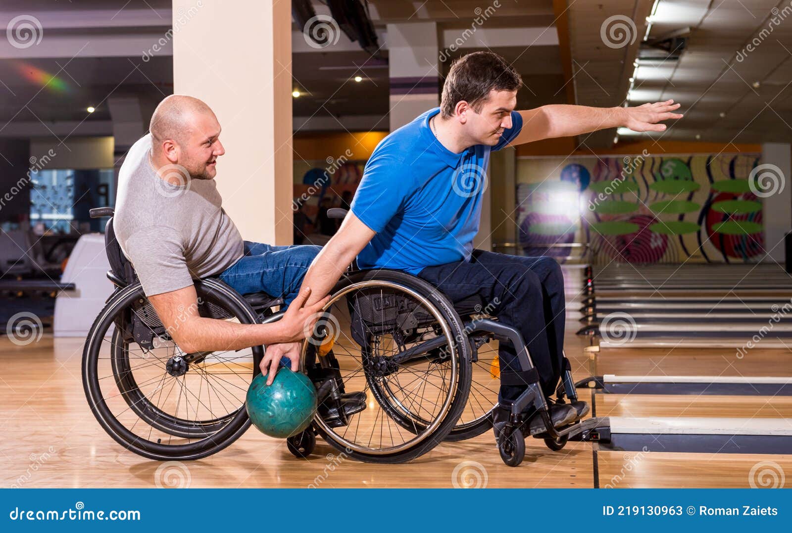 Two Young Disabled Men in Wheelchairs Playing Bowling in the Club Stock ...