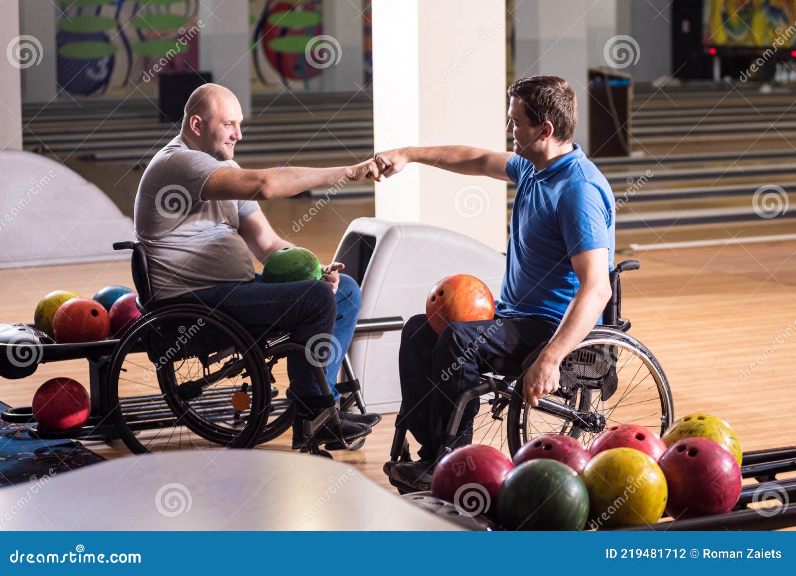 Two Young Disabled Men in Wheelchairs Playing Bowling in the Club Stock ...