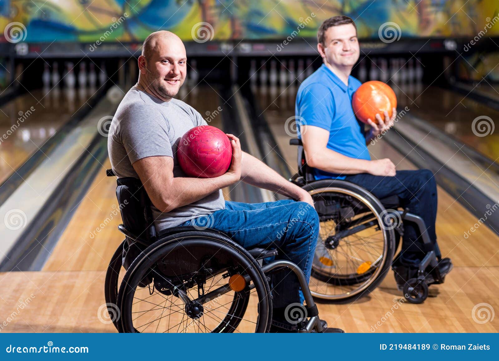 Two Young Disabled Men in Wheelchairs Playing Bowling in the Club Stock ...