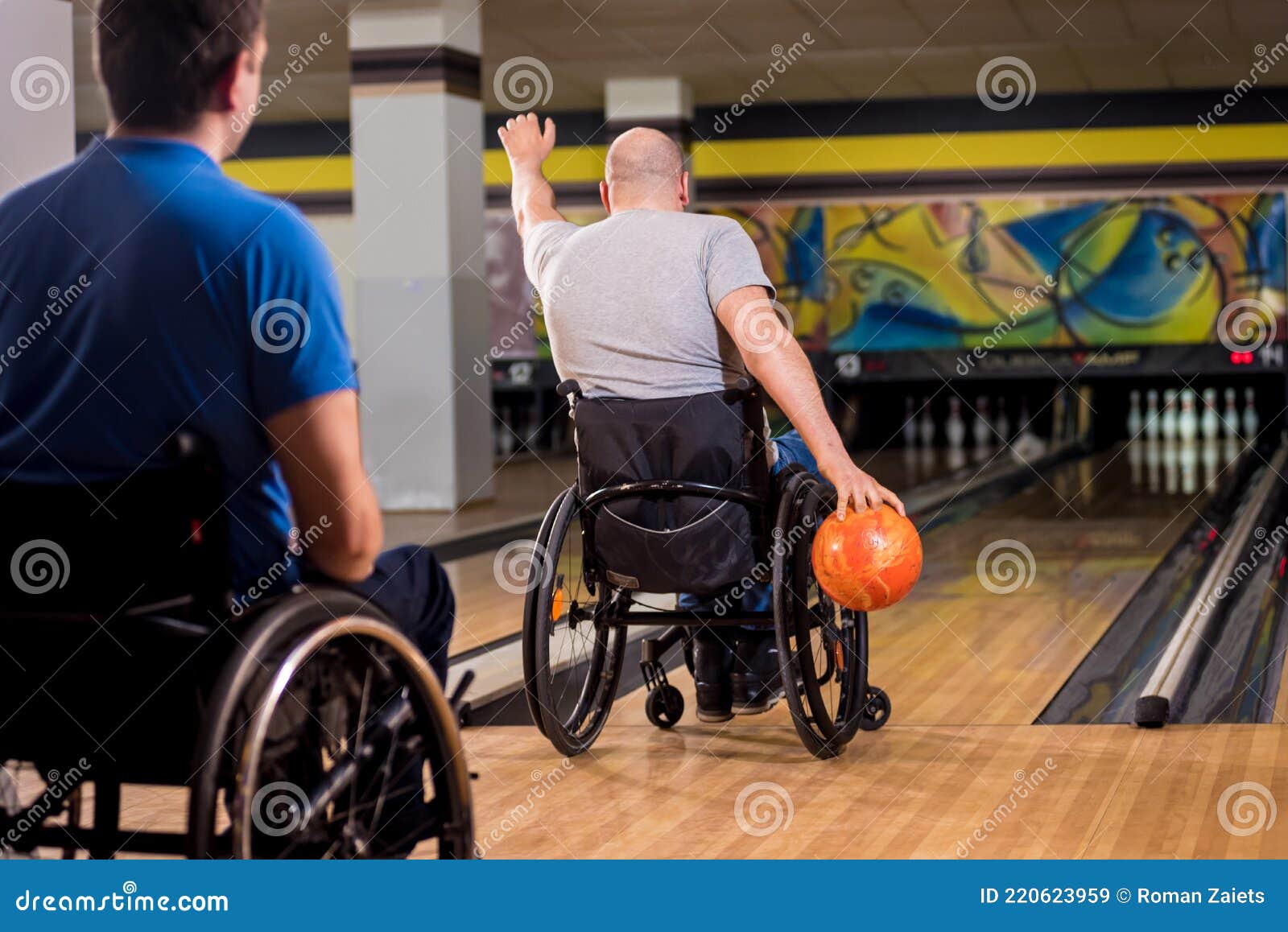 Two Young Disabled Men in Wheelchairs Playing Bowling in the Club Stock ...