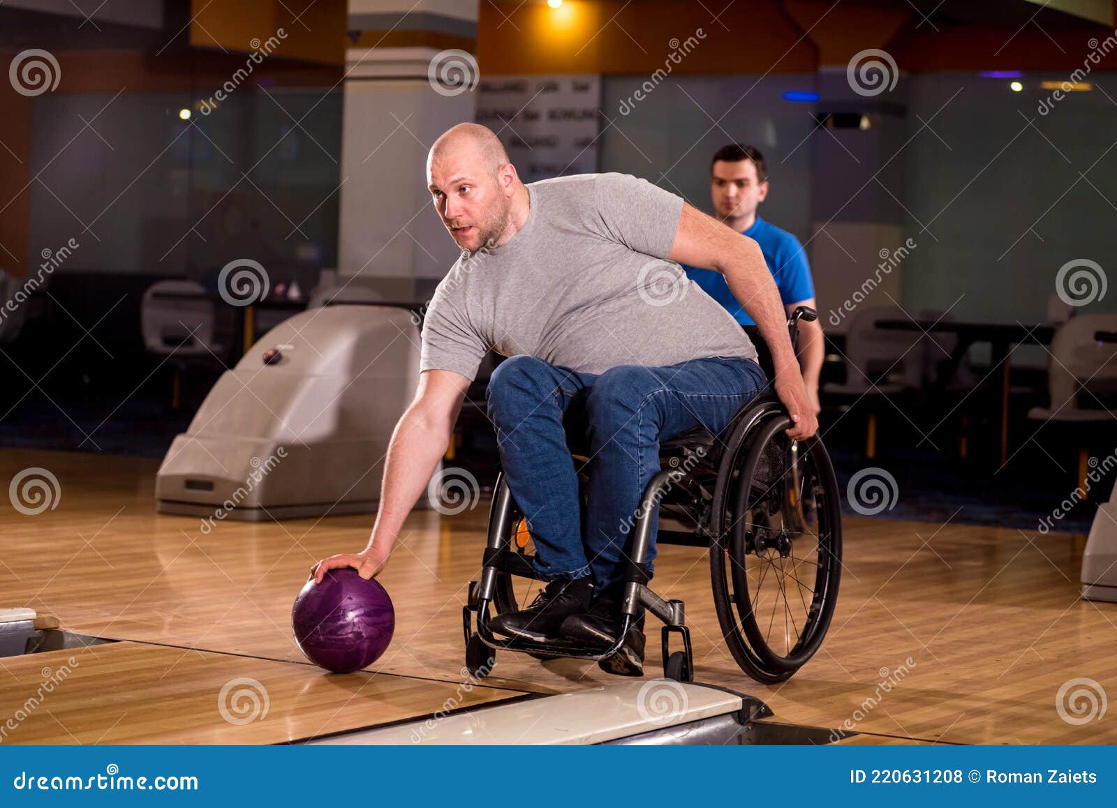 Two Young Disabled Men in Wheelchairs Playing Bowling in the Club Stock ...