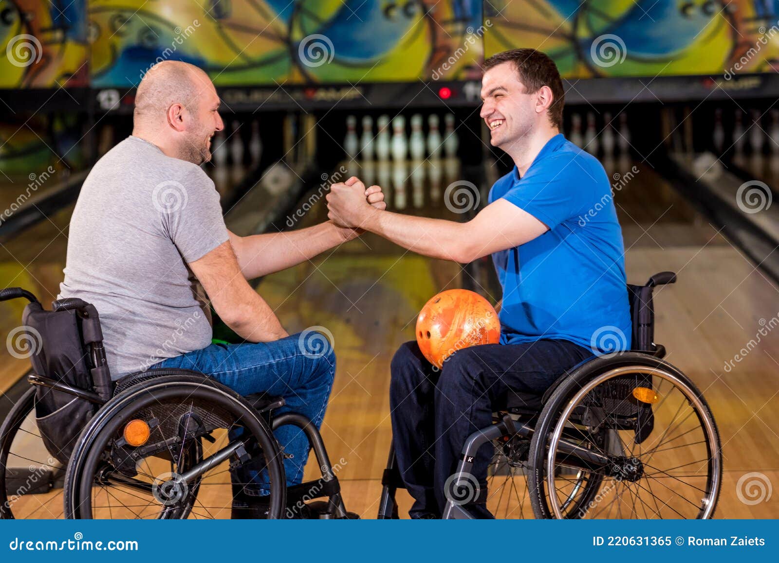 Two Young Disabled Men in Wheelchairs Playing Bowling in the Club Stock ...