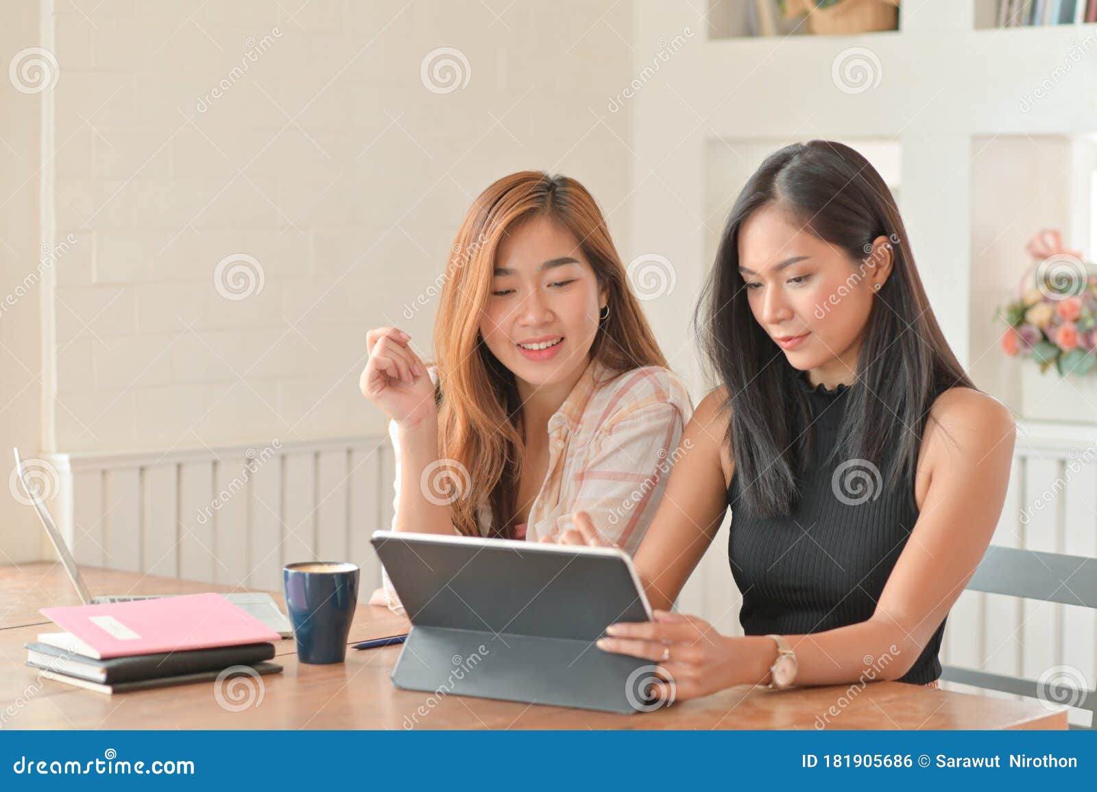 Two Young Female Students Using a Laptop To Study Online at Home in the ...
