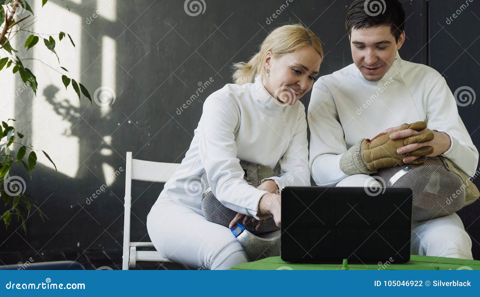 Two Young Fencers Man And Woman Watching Fencing Tutorial On Laptop ...