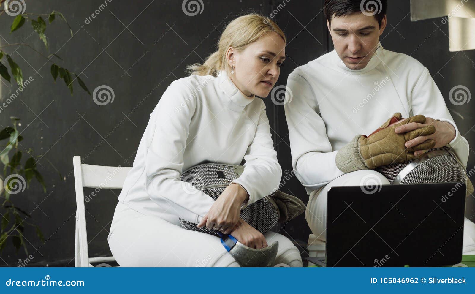 Two Young Fencers Man And Woman Watching Fencing Tutorial On Laptop ...