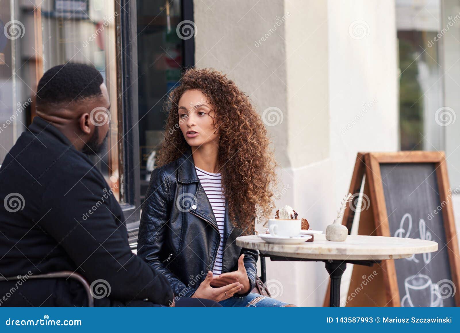 Two Young Friends Talking Together at a Sidewalk Cafe Stock Image ...