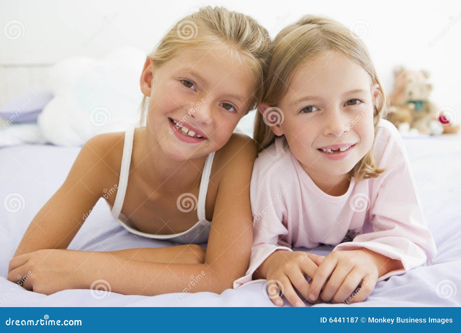 Two Young Girls In Their Pajamas Lying On A Bed Stock Image Image Of