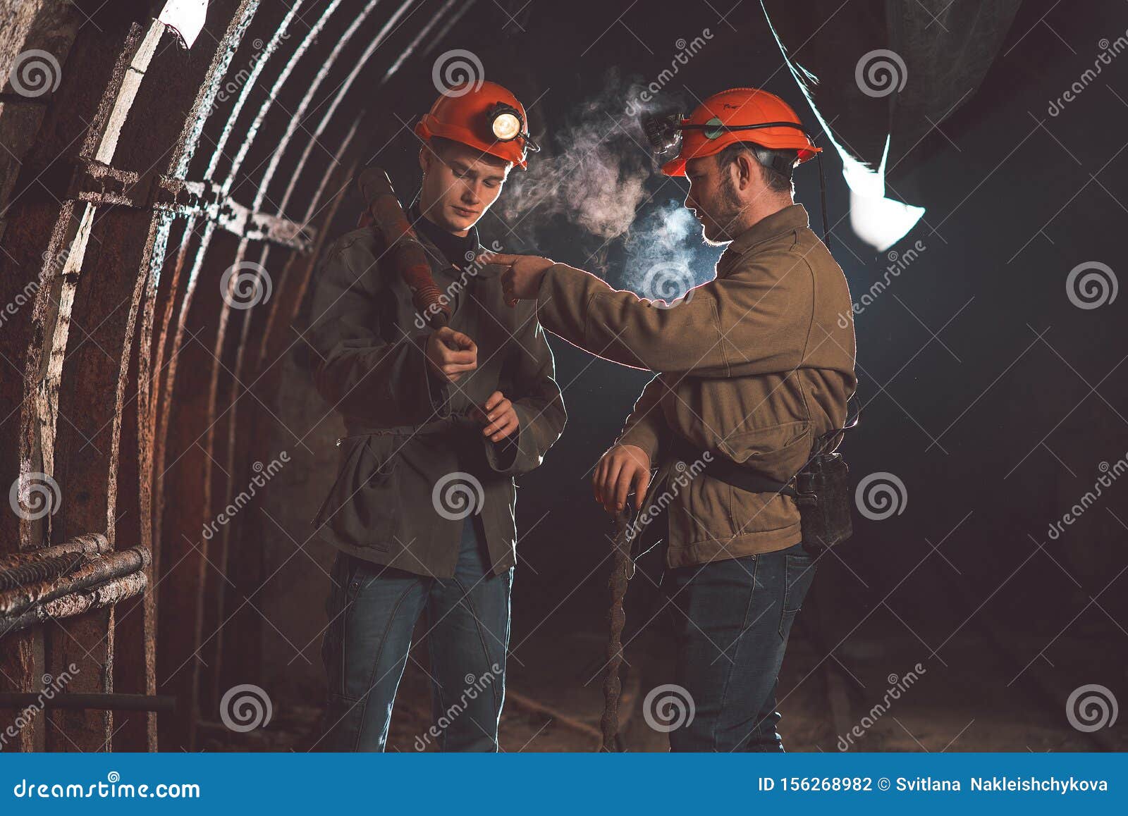 Two Young Guys in Special Clothes and Helmets Standing in the Mine ...