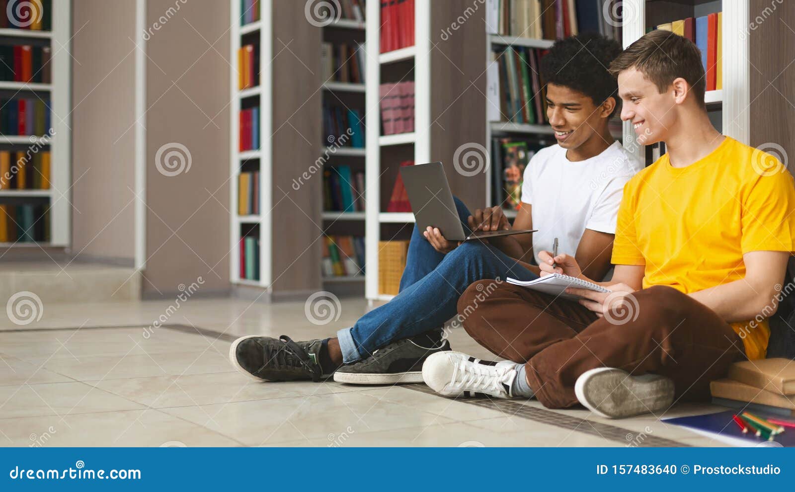 Two Young Guys Studying on Floor in Library Stock Photo - Image of ...