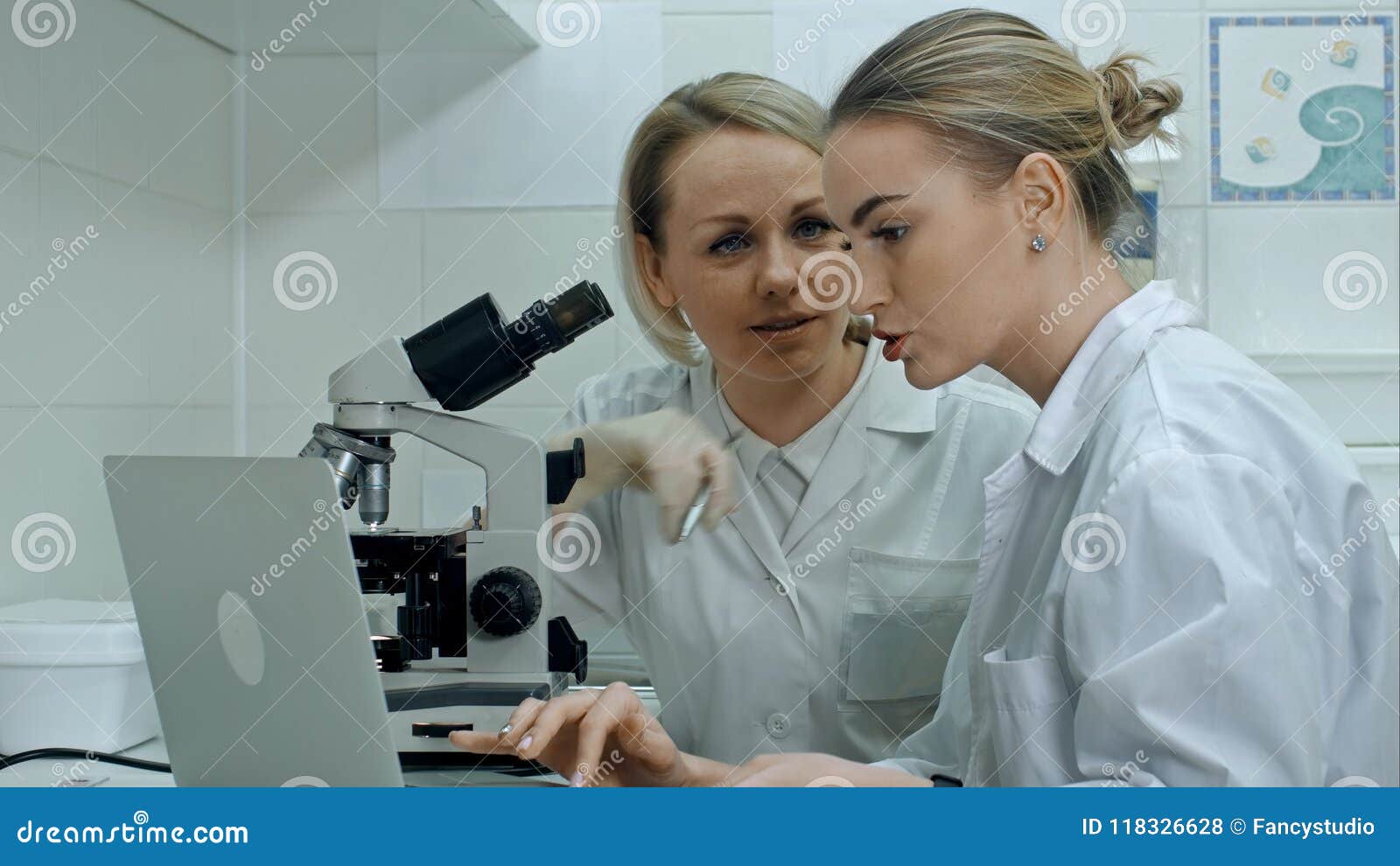 Two Young Laboratory Technician with Laptop and a Microscope in the ...