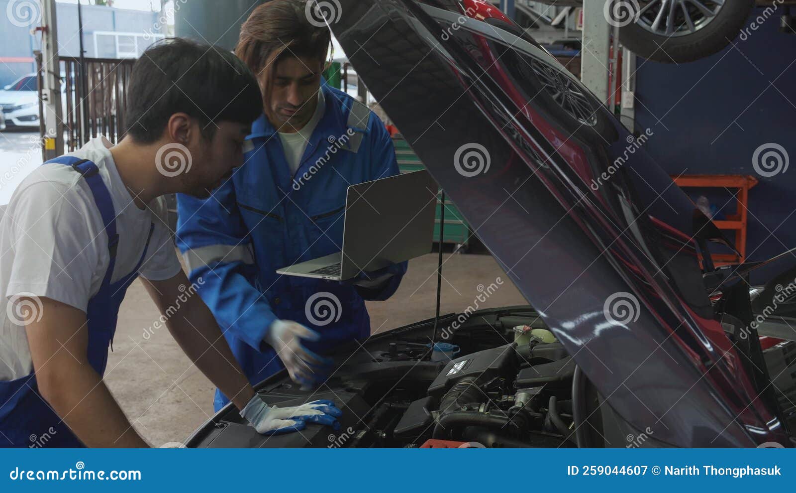 Two Young Man is Mechanic Using Laptop Computer Checking Engine of Car ...
