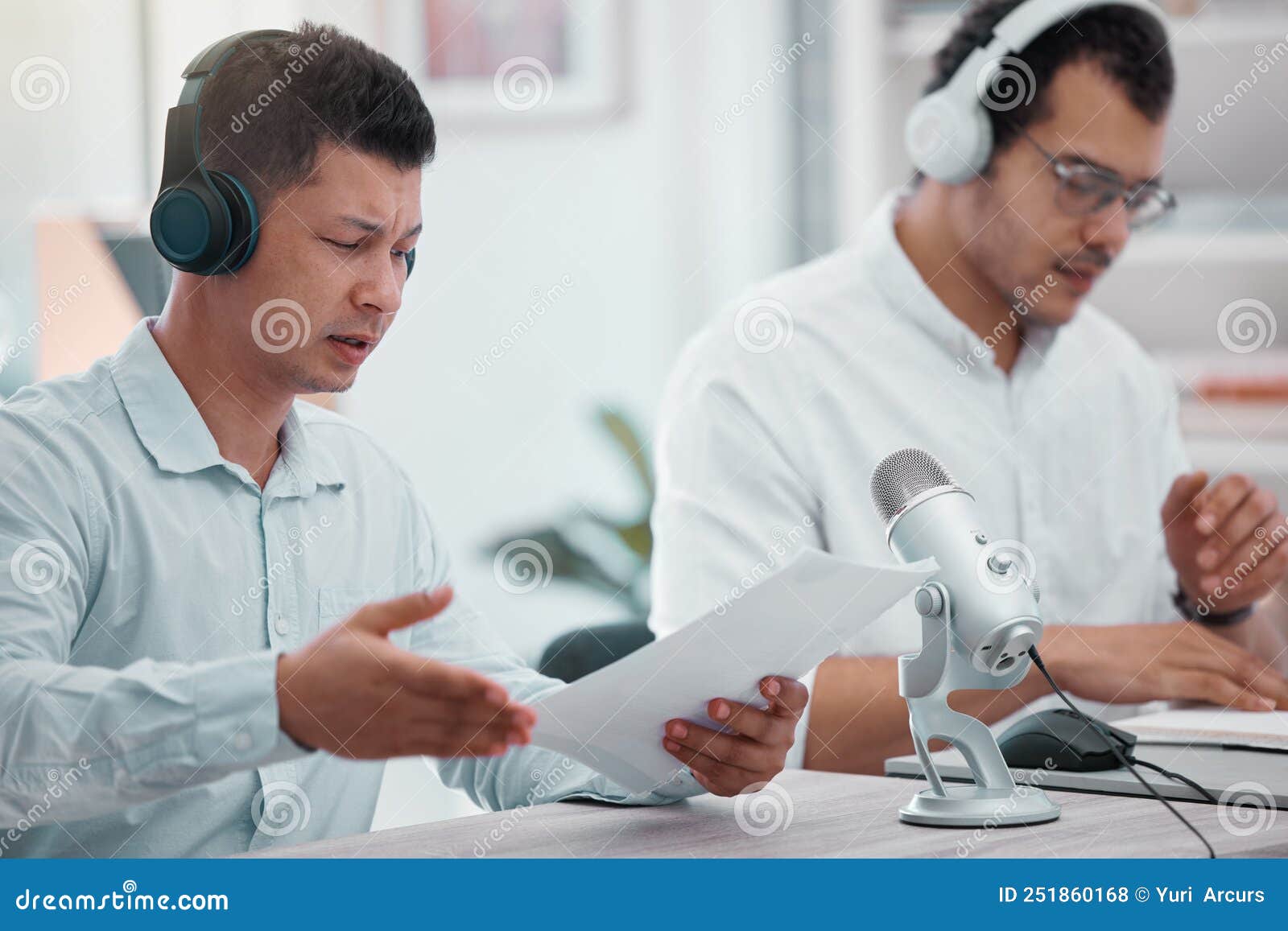 This Just in.... Two Young Men Going through Paper while Doing a ...