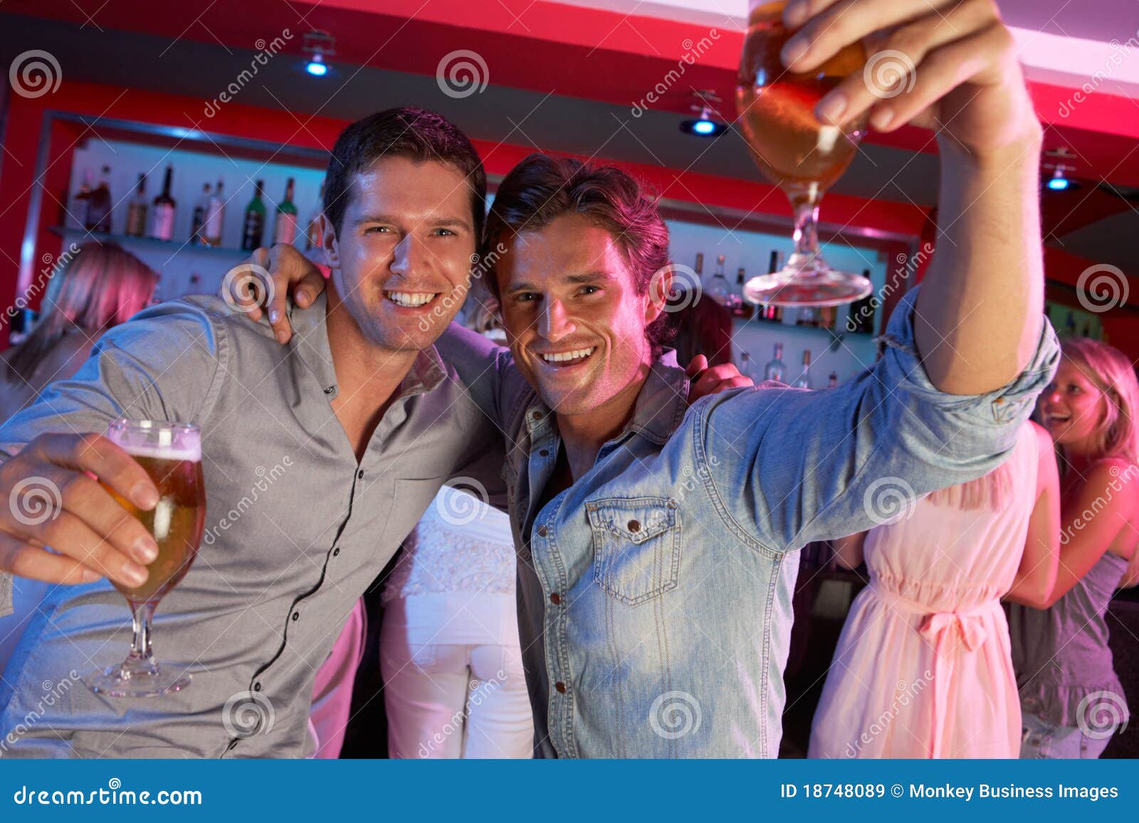 Two Young Men Having Fun in Busy Bar Stock Image - Image of twenties ...