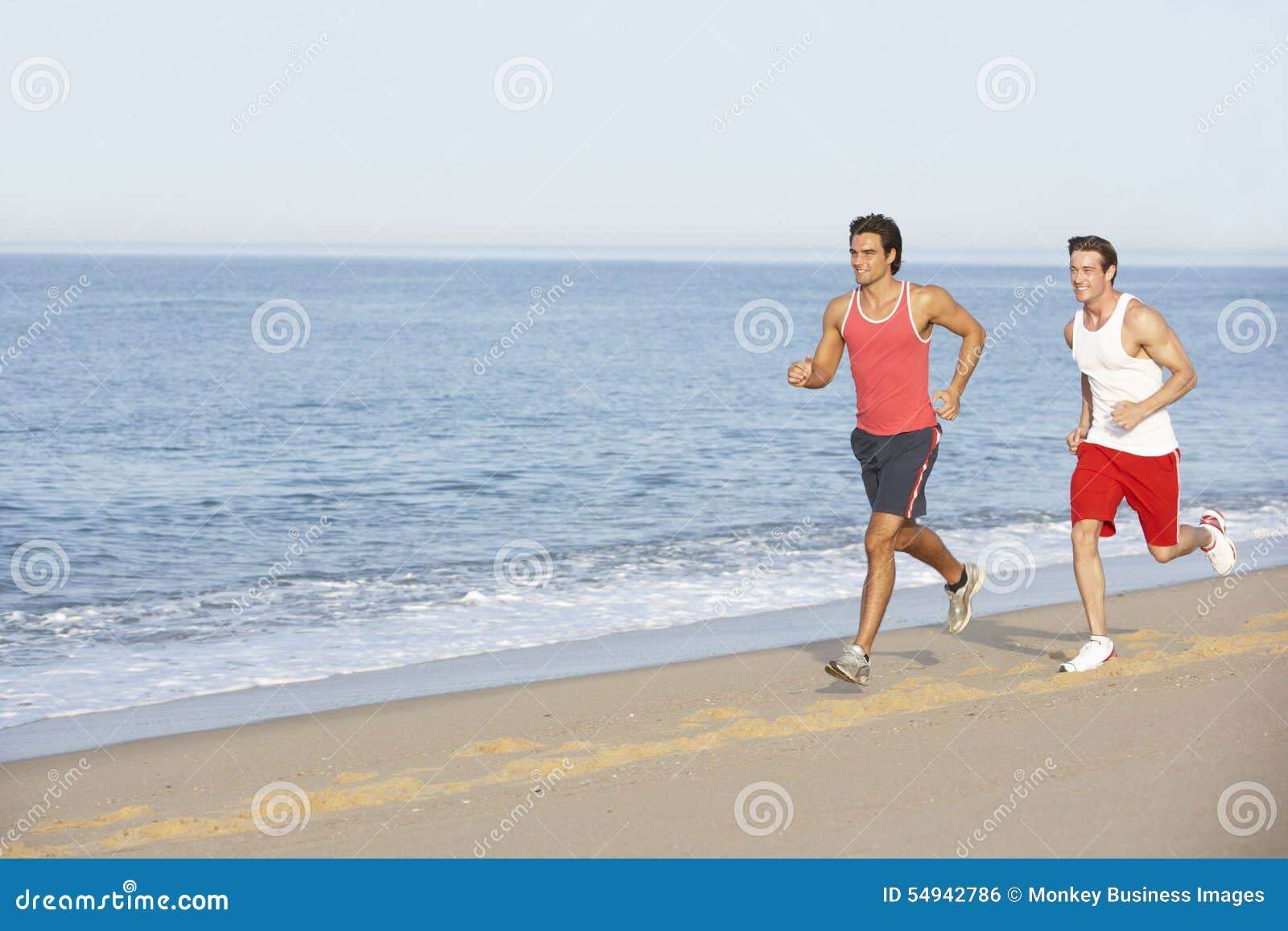 Two Young Men Jogging Along Beach Stock Photo - Image of person ...