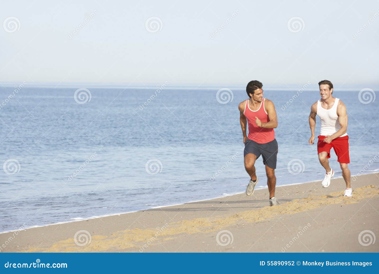 Two Young Men Jogging Along Beach Stock Photo - Image of full ...