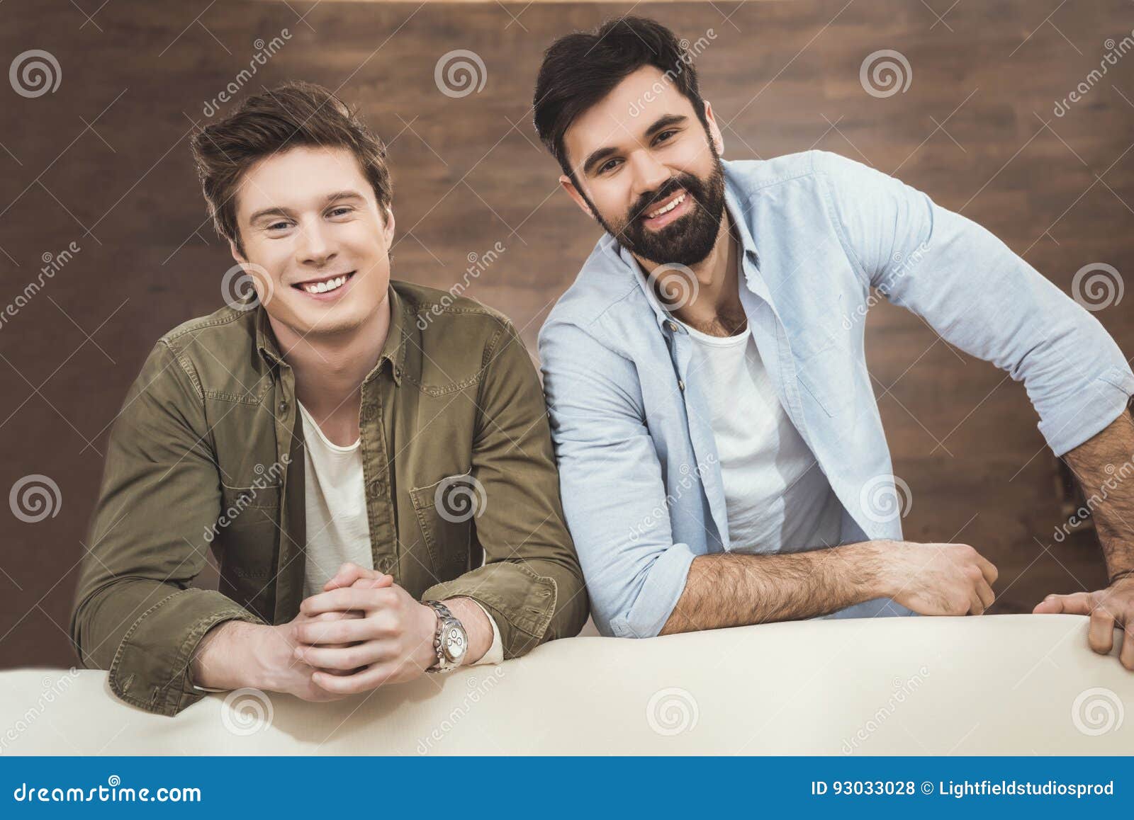 Two Young Men Leaning on Sofa Stock Photo - Image of daytime, people ...
