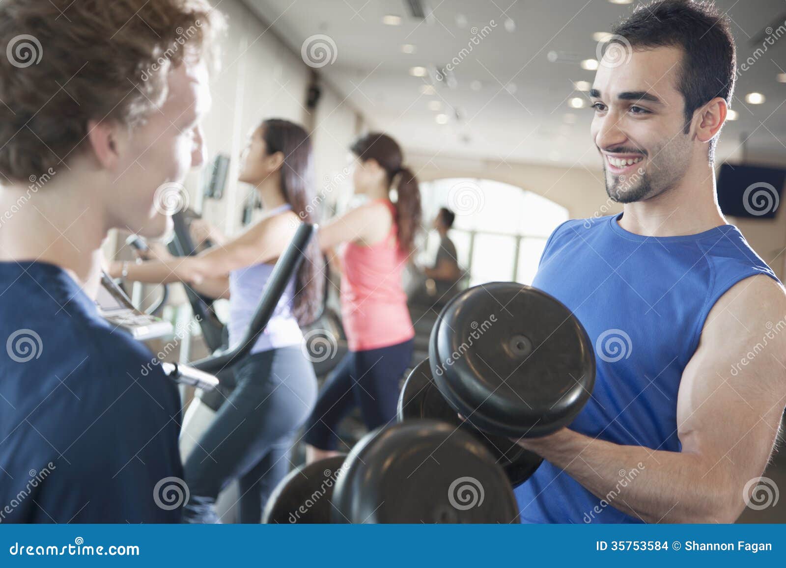 Two Young Men Smiling and Lifting Weights in the Gym Stock Photo ...