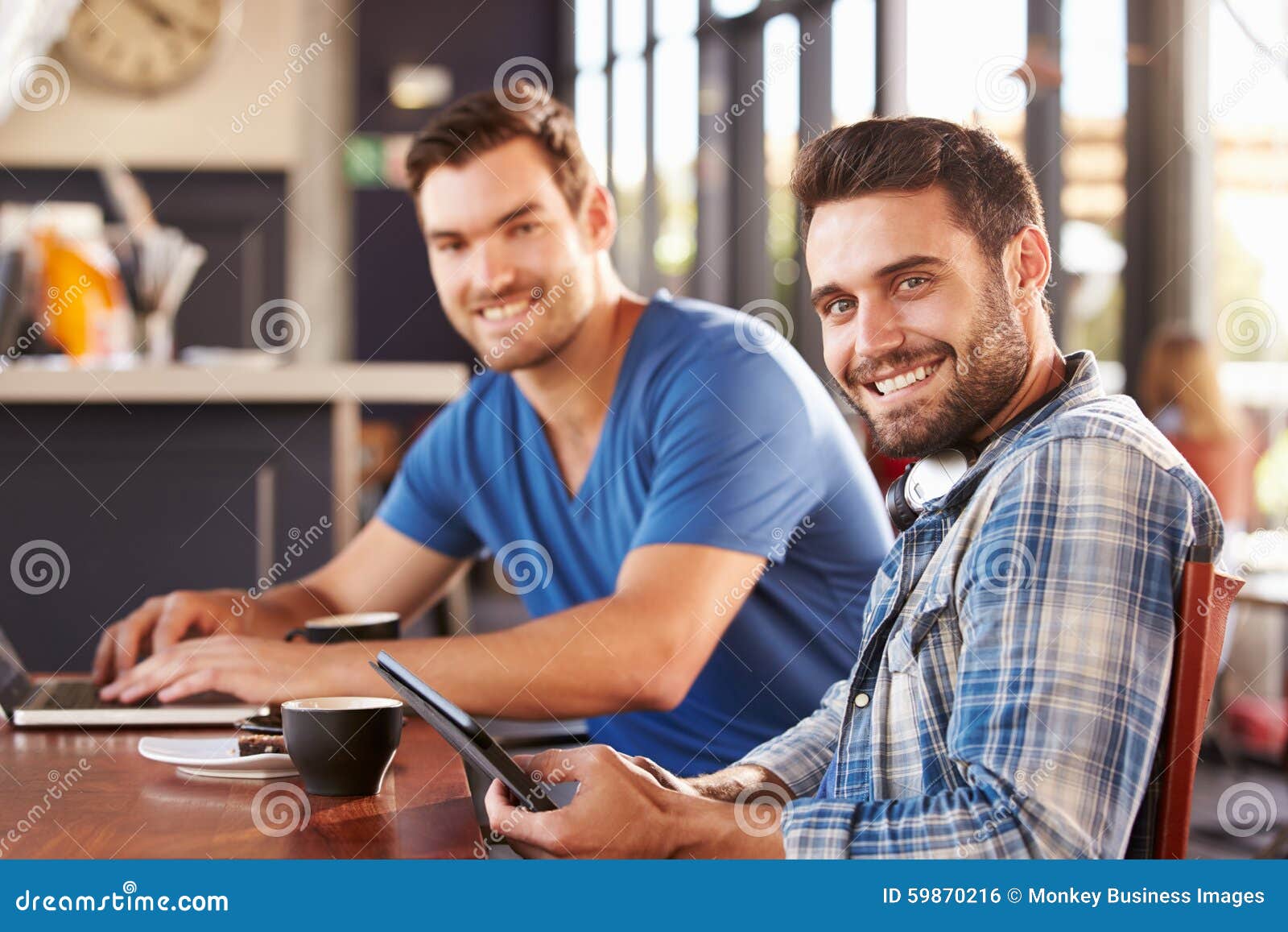 Two Young Men Working on Computers at a Coffee Shop Stock Photo - Image ...