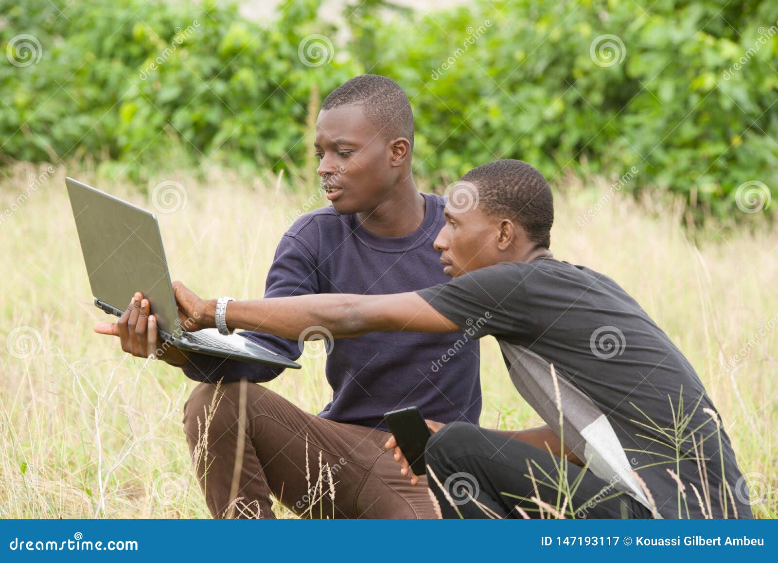 Two Young Men Working on Laptop Outdoors Stock Image - Image of ...