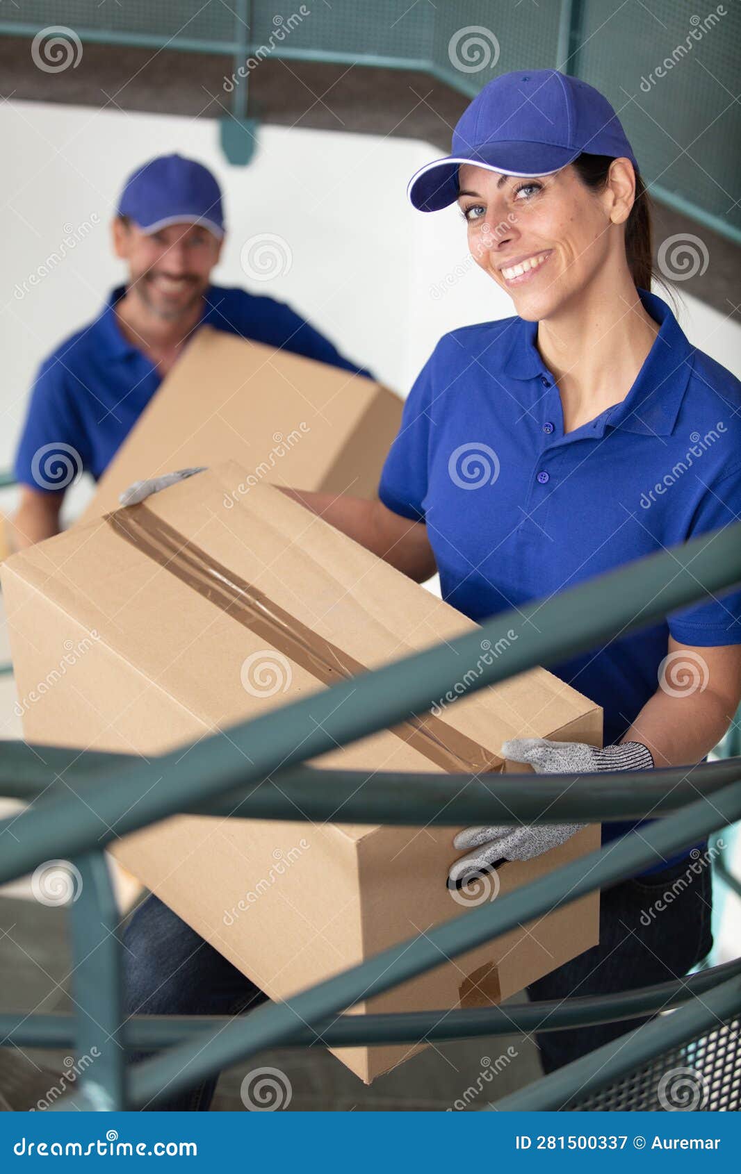 Two Young Movers in Blue Uniform Carrying Cardboard Boxes Stock Image ...