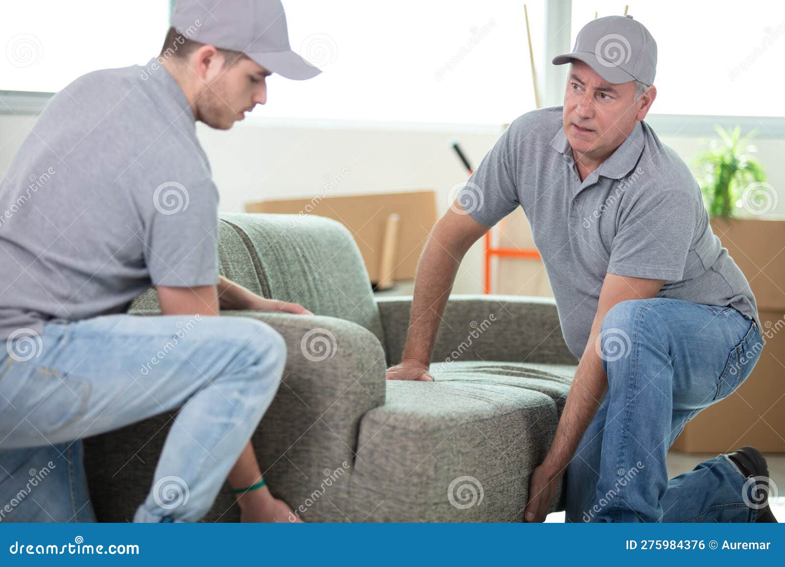 Two Young Movers Moving Sofa in New Home Stock Photo - Image of move ...