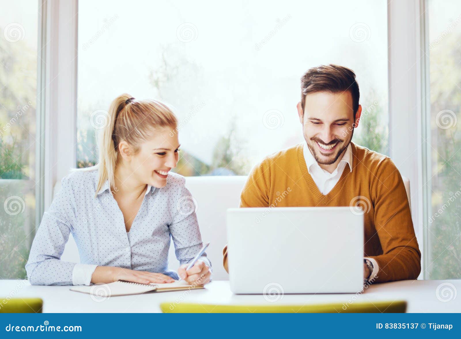 Two Young People Sitting at a Cafe, Using a Laptop Stock Image - Image ...