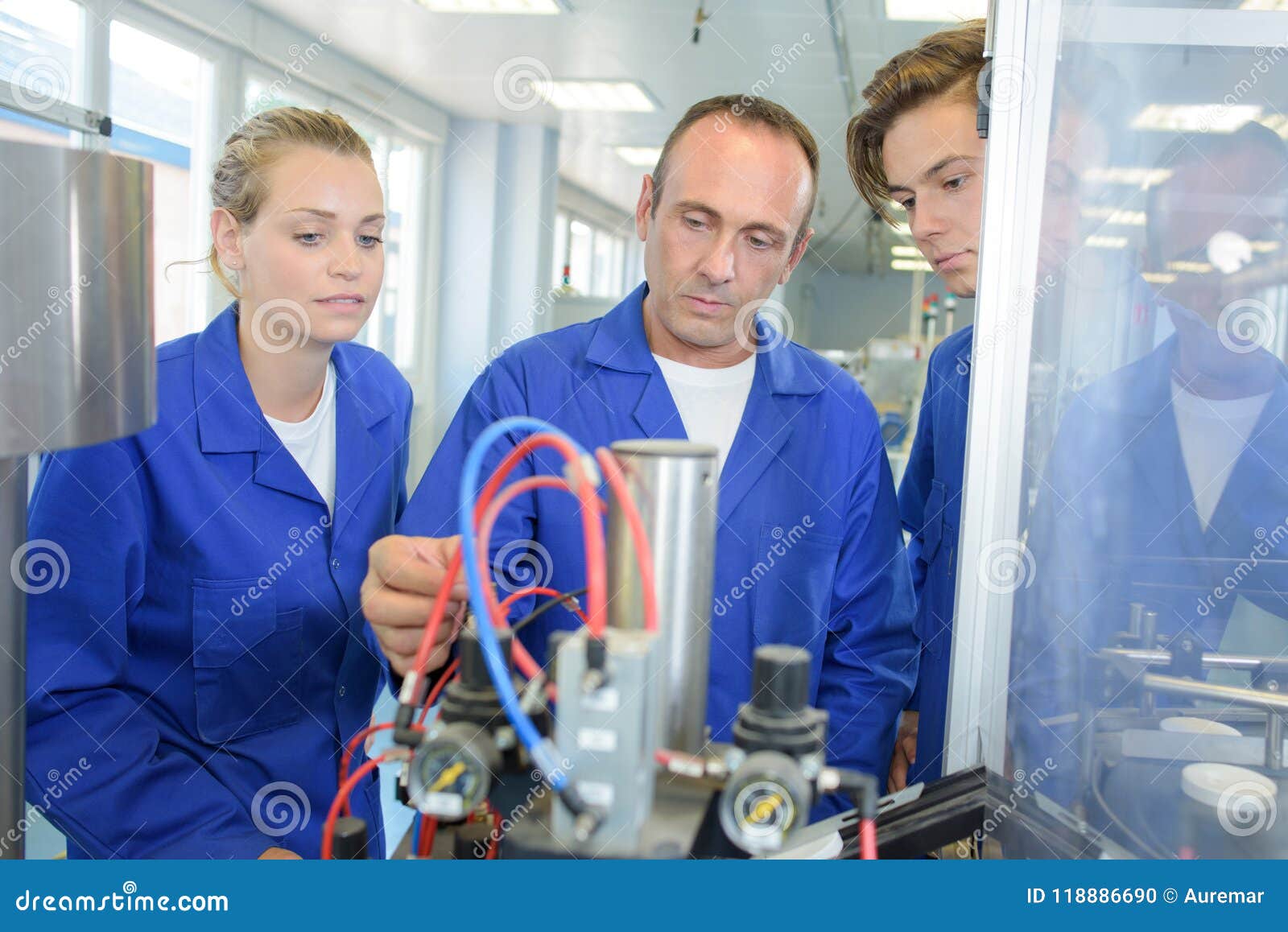 Two Young People Watching Man Work on Machine Stock Photo - Image of ...