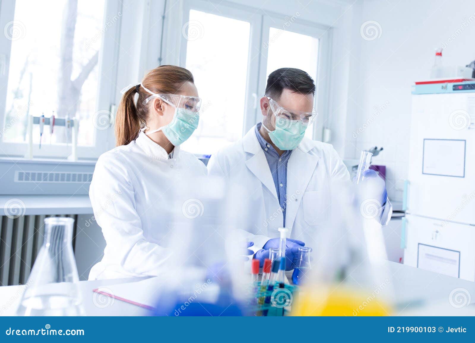 Two Young Scientists Doing Experiments Researching in Laboratory ...
