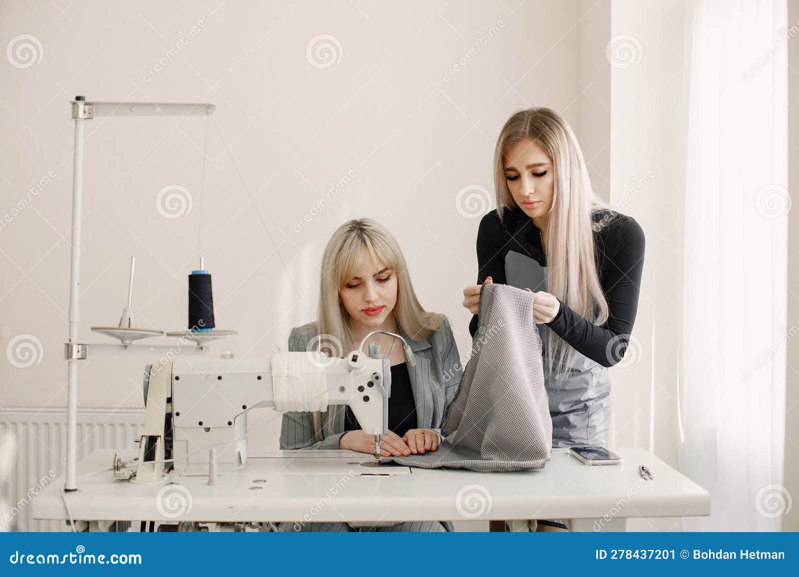 Two Young Seamstresses Sitting on the Sewing Machine in Her Workshop ...