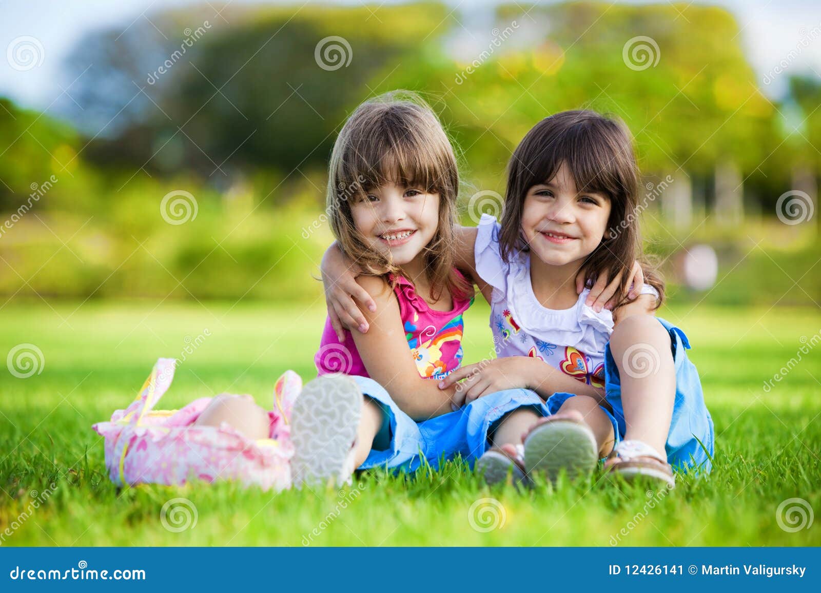 Two Young Smiling Girls Hugging in the Grass Stock Image - Image of ...