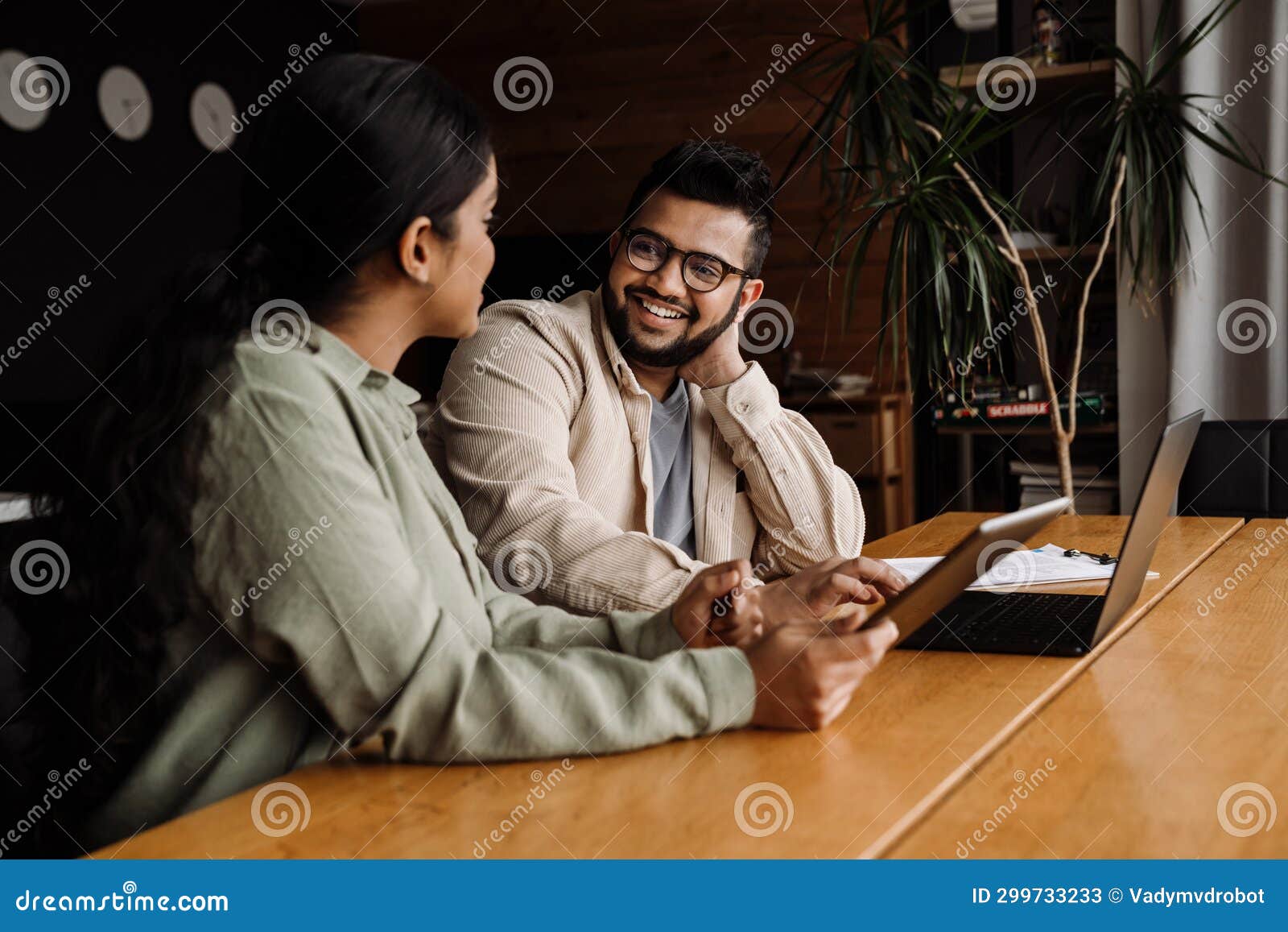 Two Indian Colleagues Using Laptop and Tablet while Working Together in ...