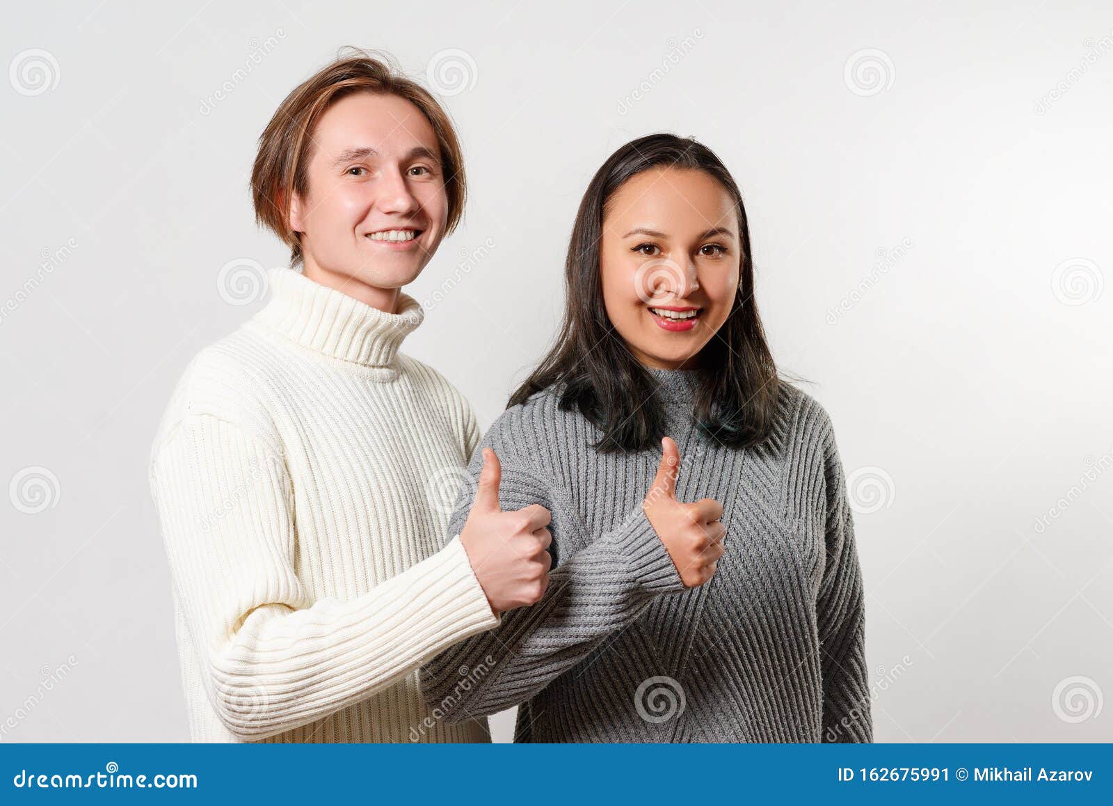 Two Young Smiling People with Thumbs-up Gesture on White Stock Image ...