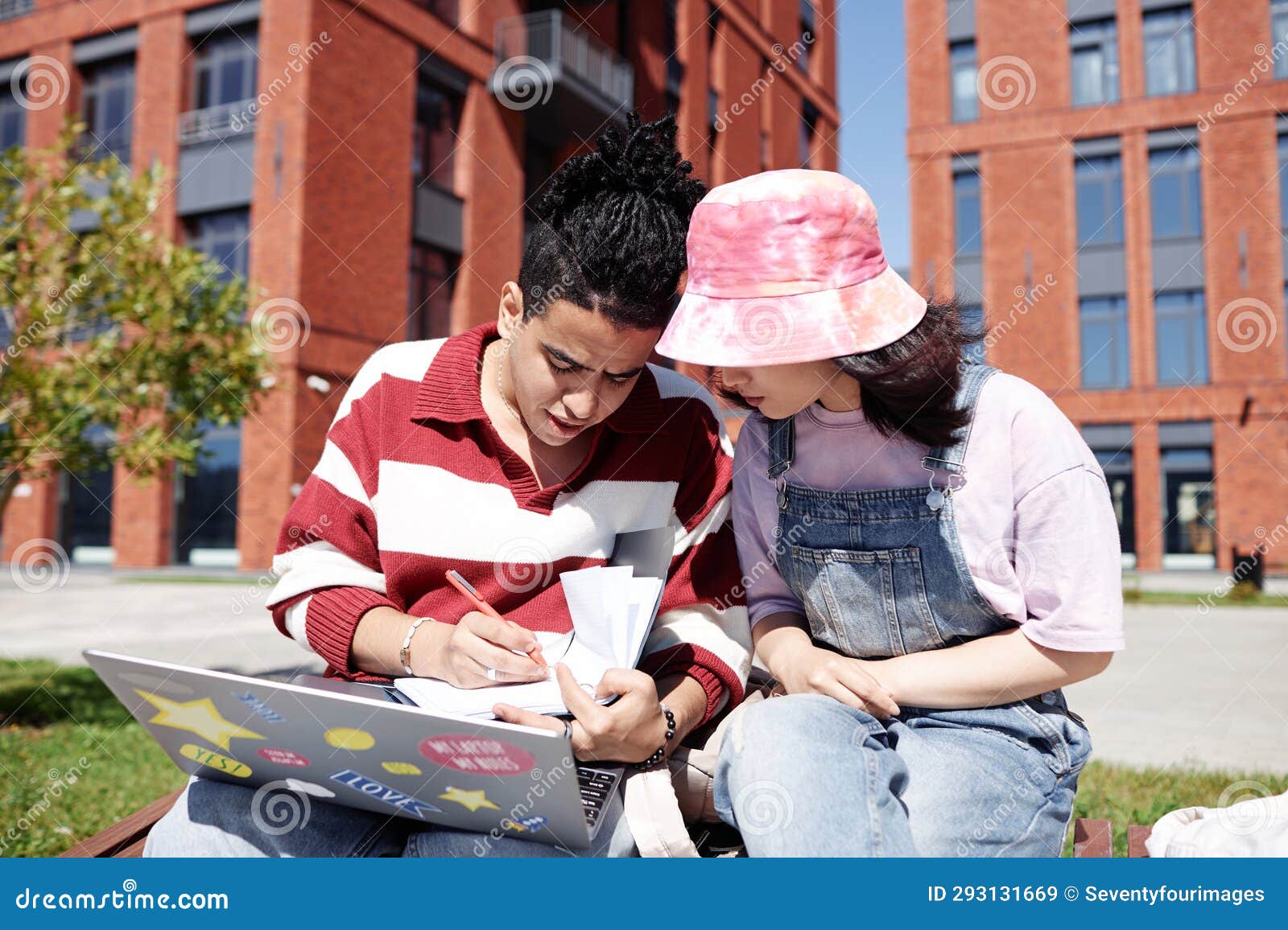 Two Young Students Using Laptop Outdoors Studying Together on College ...