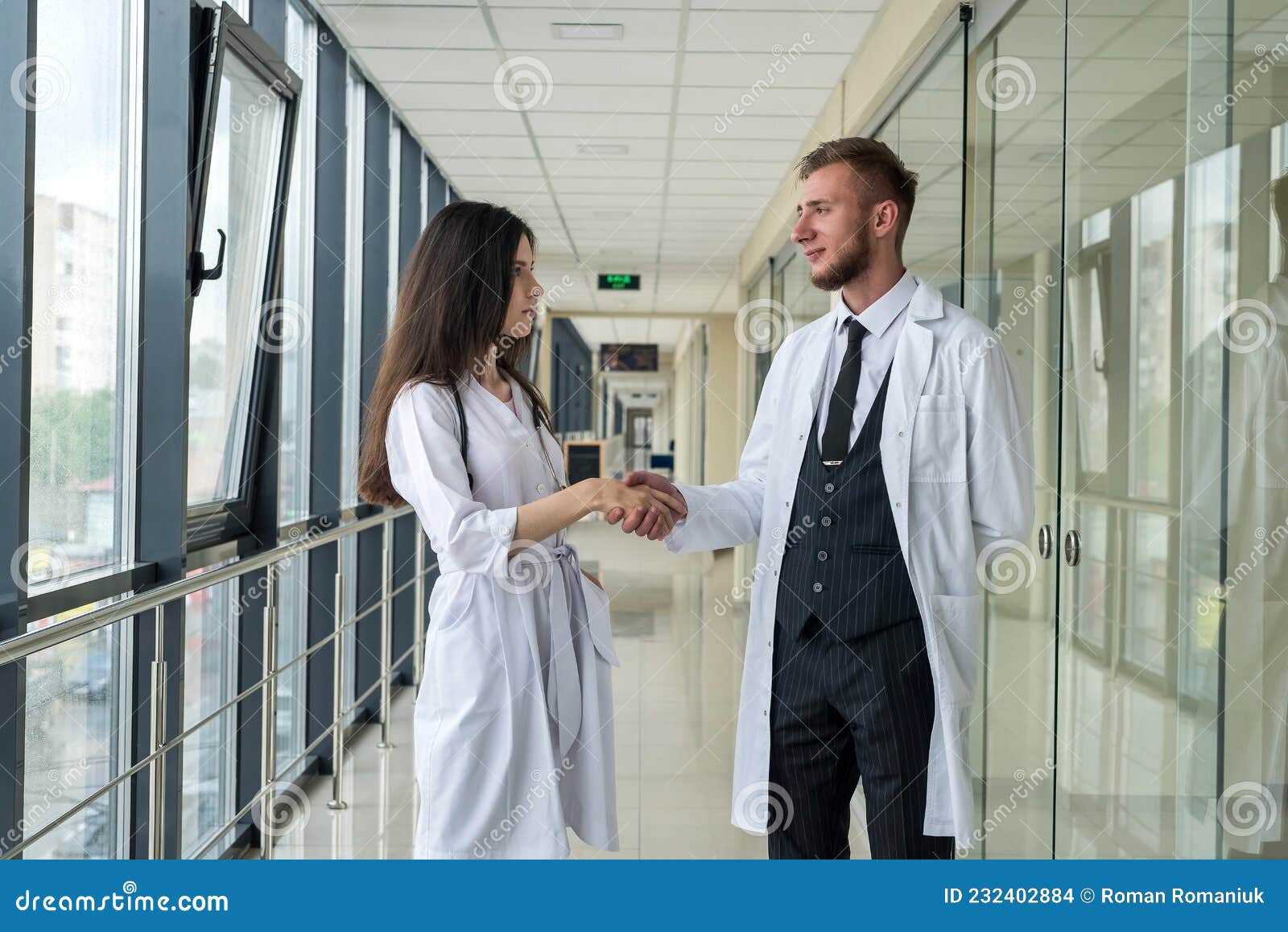 Two Young Trainee Doctors Pose in the Corridor of a Modern Hospital ...